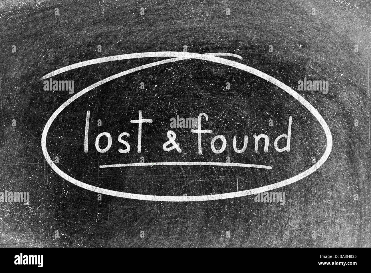 White chalk hand writing in word lost and found and circle shape on ...
