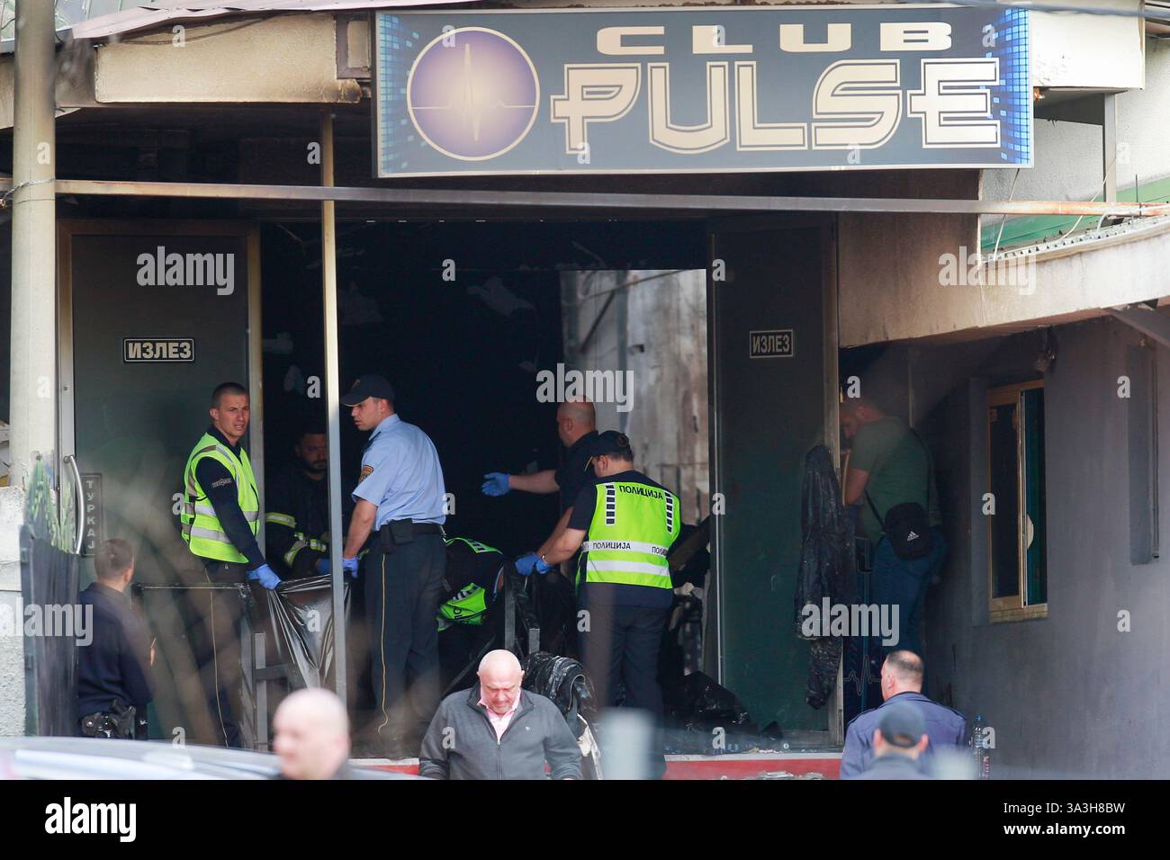 Police officers hold plastic bags on the site of a nightclub in the ...