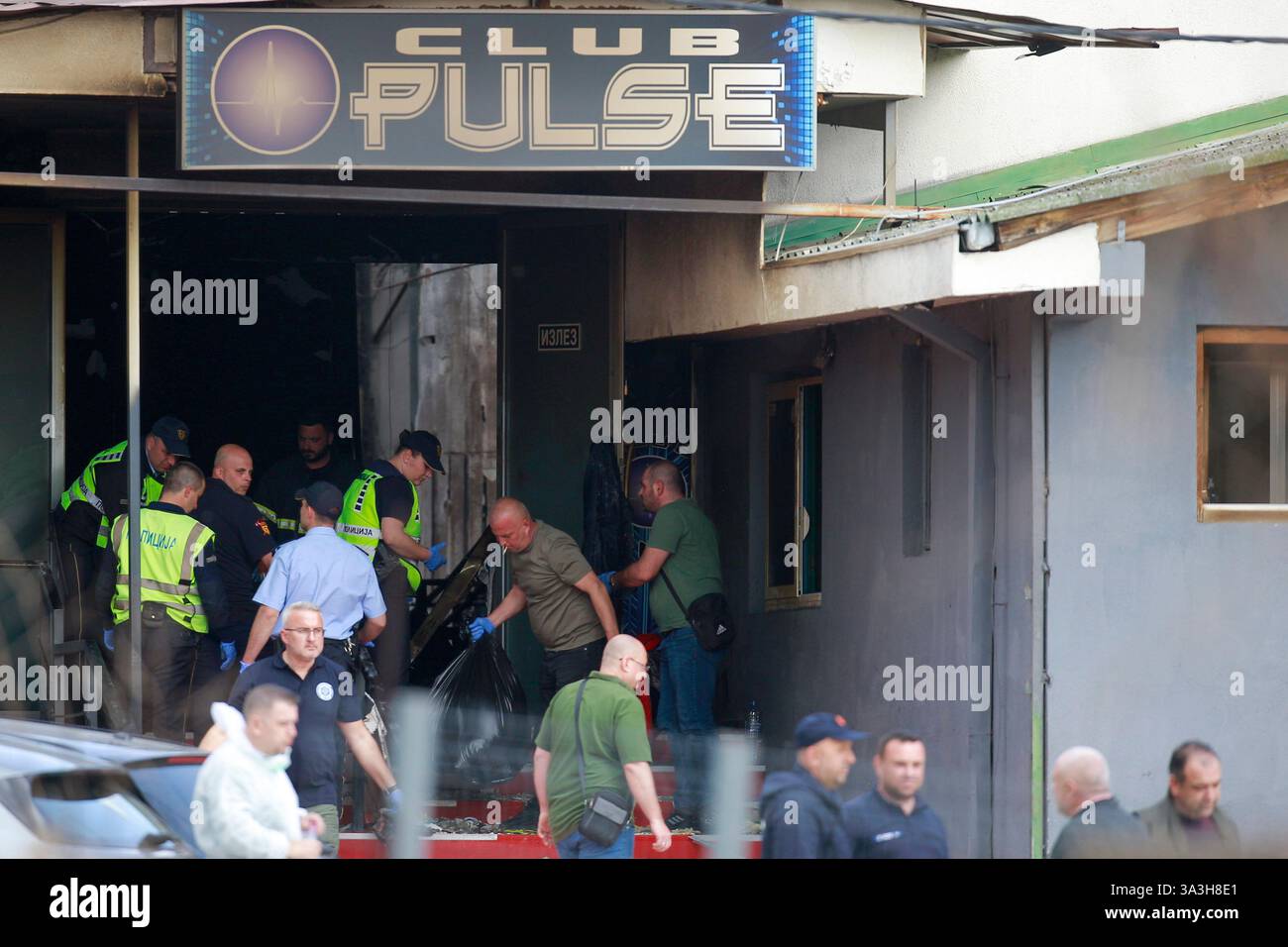 Police officers hold plastic bags on the site of a nightclub in the ...