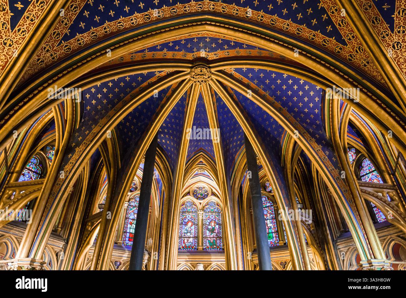 Visitors admire the intricate stained glass windows and vaulted ceilings inside Sainte-Chapelle ...