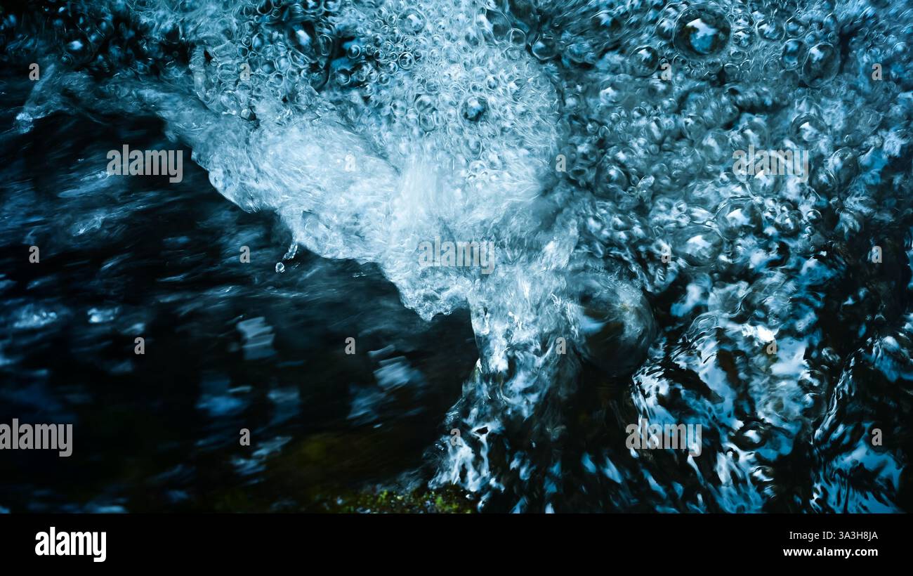 Close up of running water in a stream creek with rocks background and ...