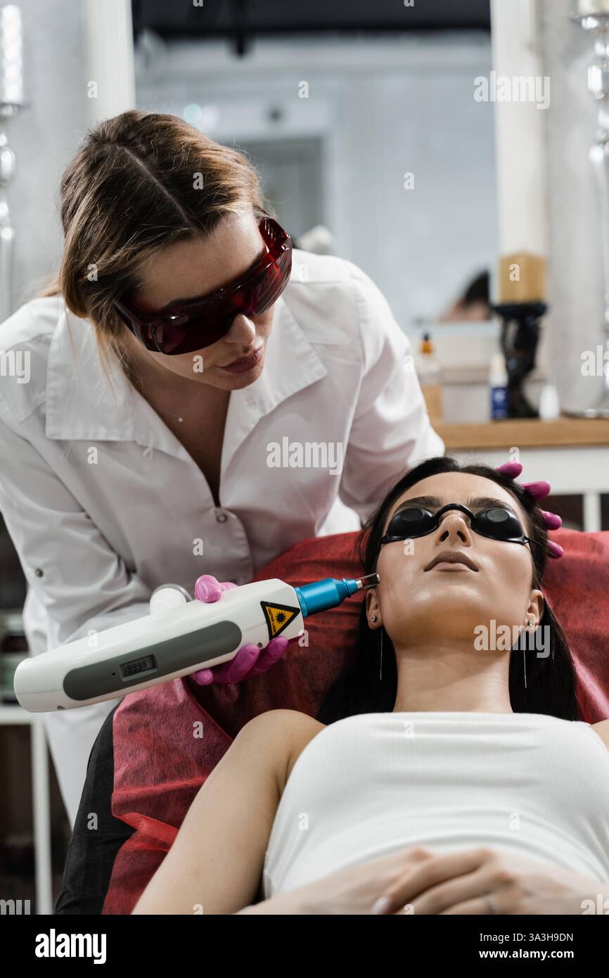 Cosmetologist cleans face of girl from pigmentation using laser ...