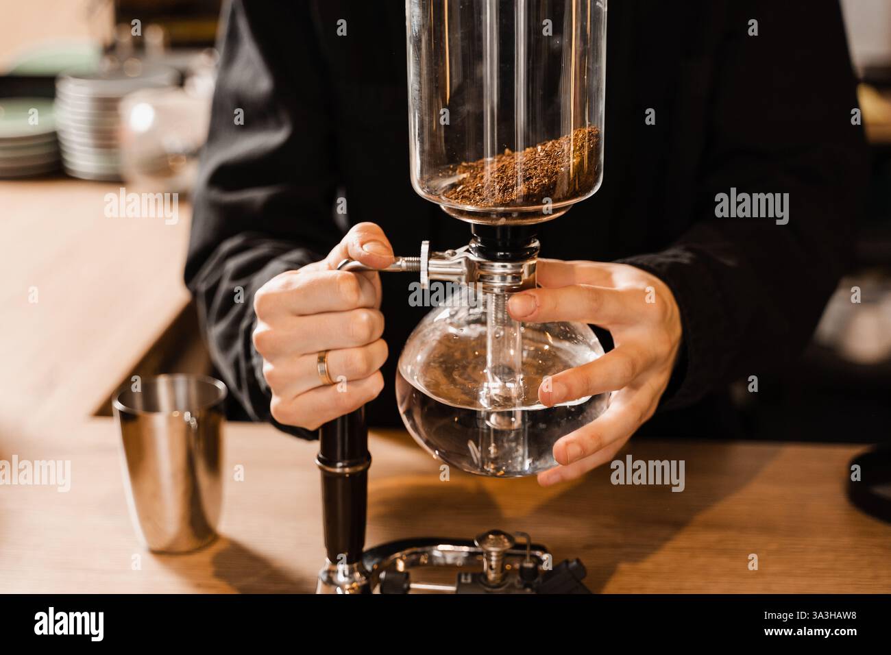 Barista is holding siphon before starting boiling water inside syphon ...