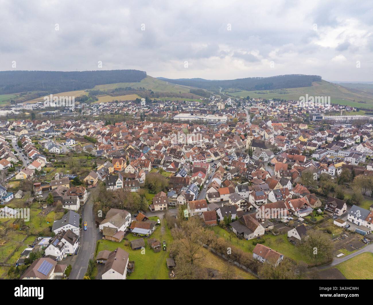 View of urban settlement with red roofs and green hills in the ...