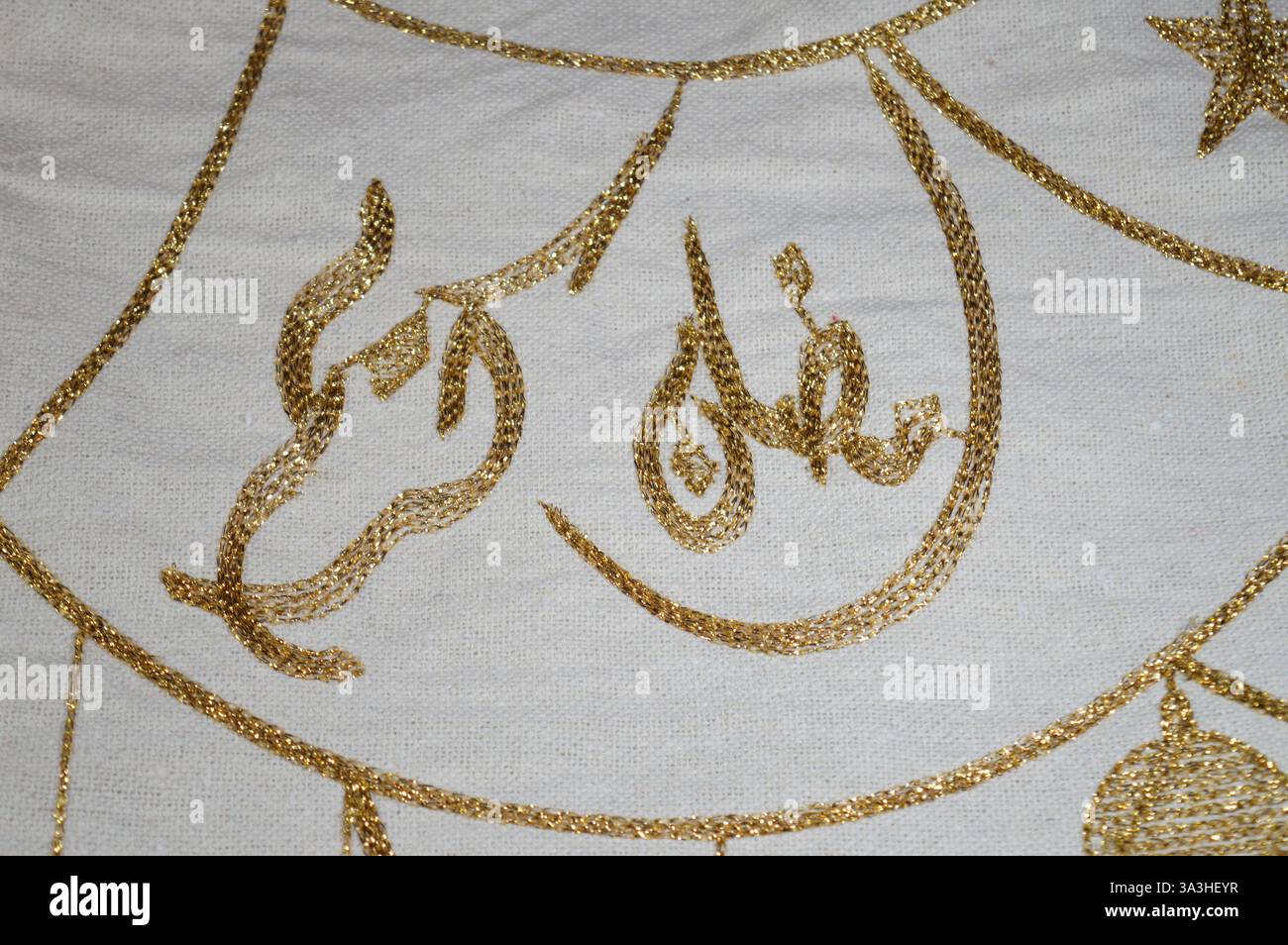 Translation of Arabic text (Happy generous Ramadan) on a fabric with ...