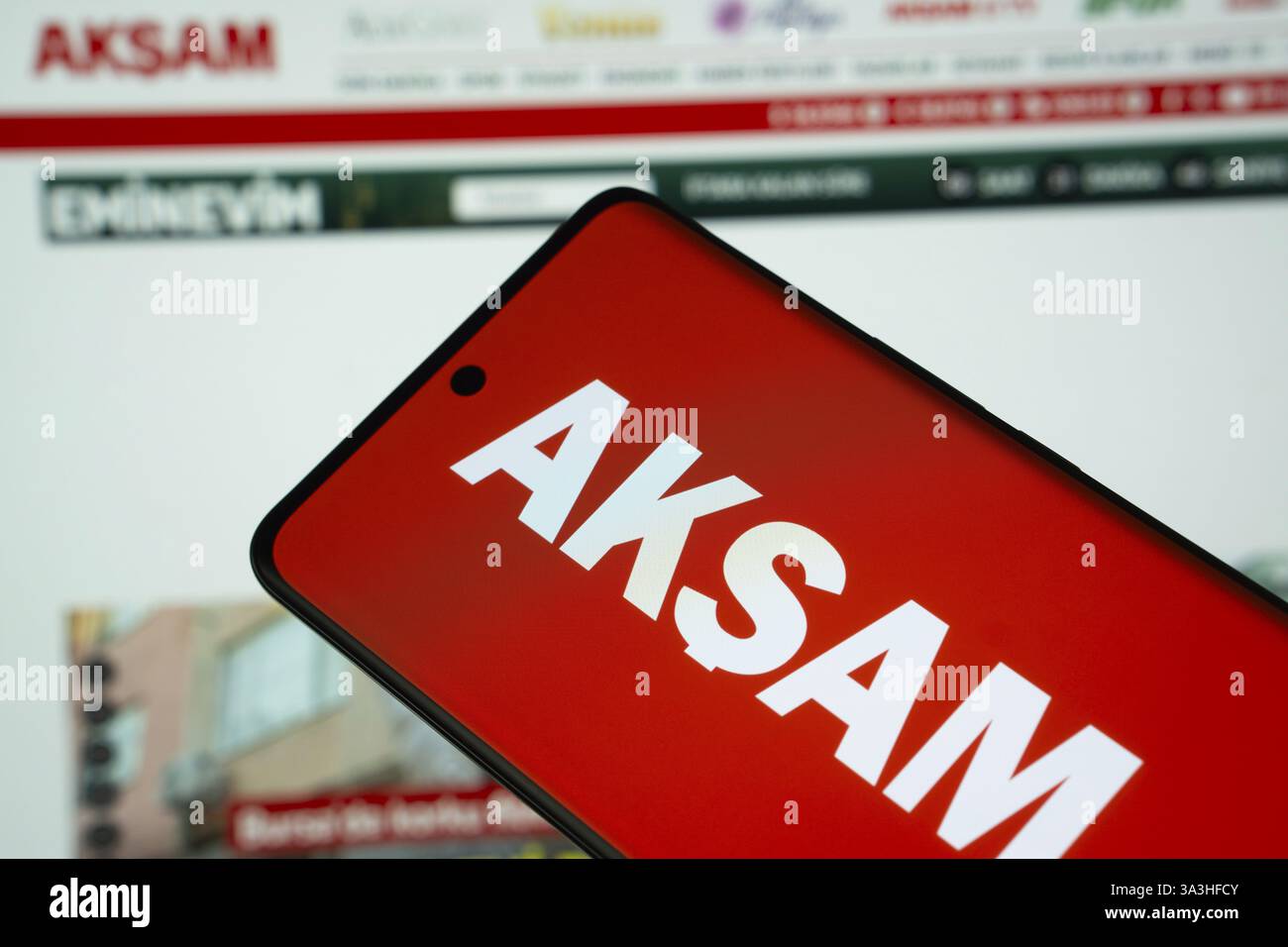 The logo of the Turkish newspaper AKSAM is displayed on a smartphone ...