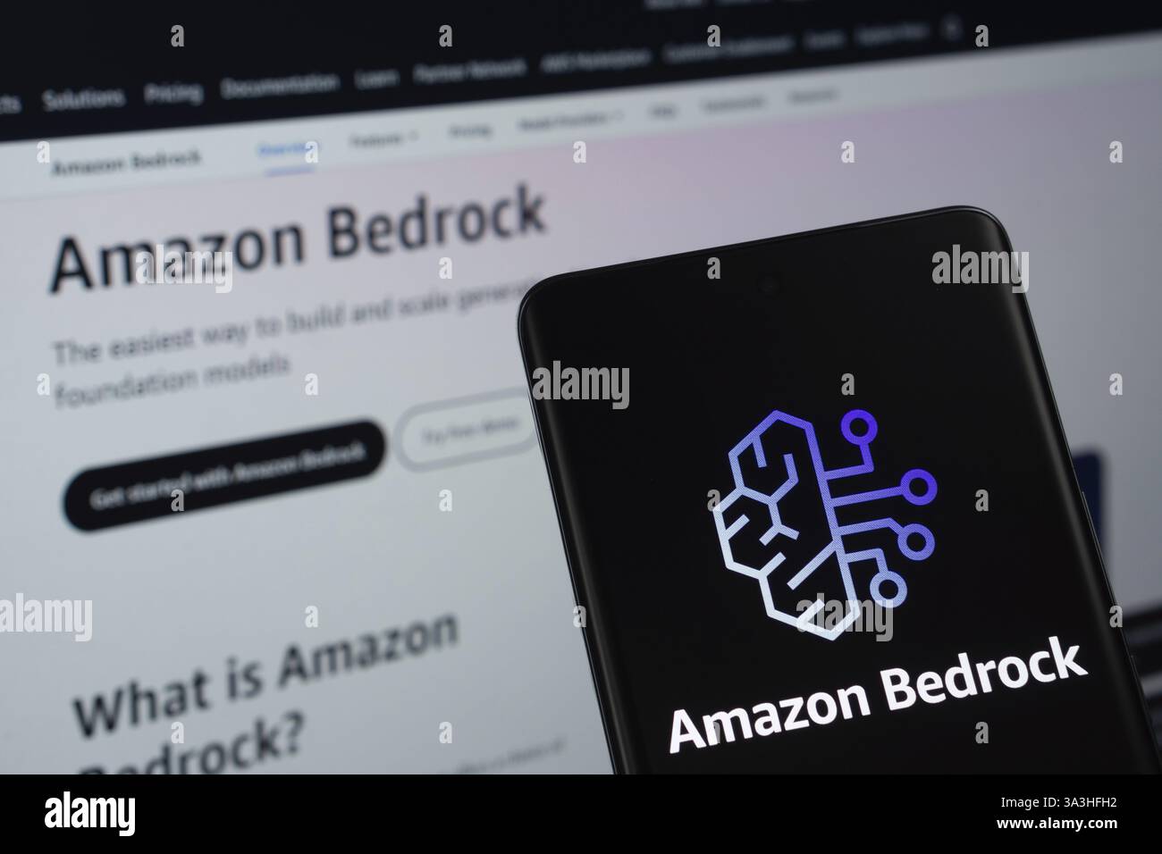 The logo of the Amazon Bedrock is displayed on a smartphone screen ...