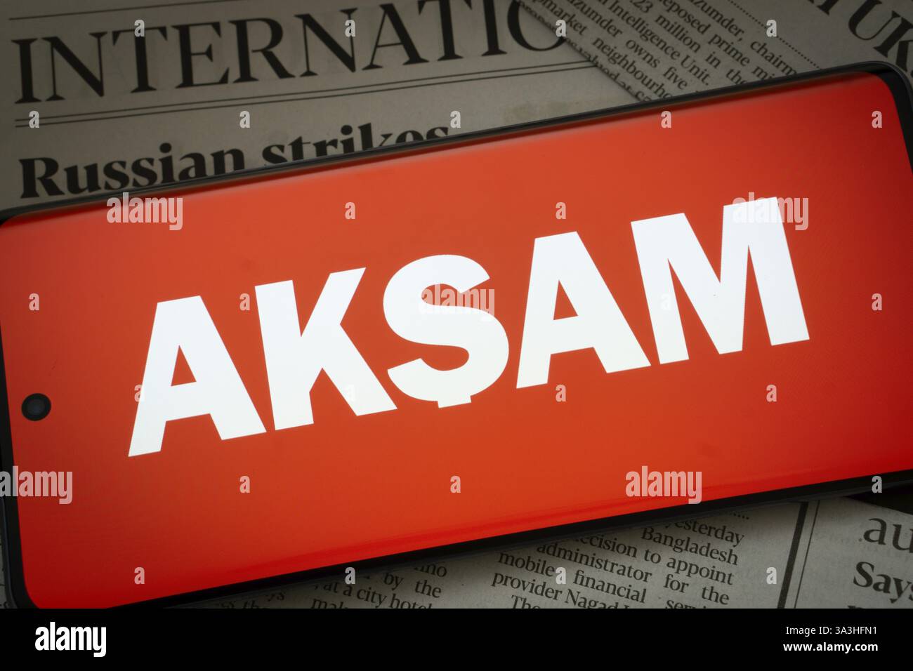The logo of the Turkish newspaper AKSAM is displayed on a smartphone ...