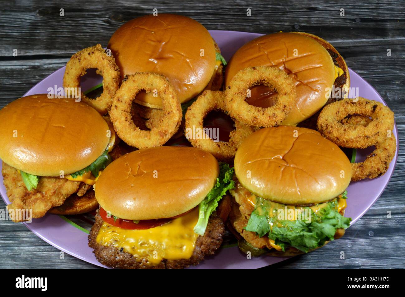 Fried onion rings with assorted sandwiches of cheeseburger, a hamburger ...