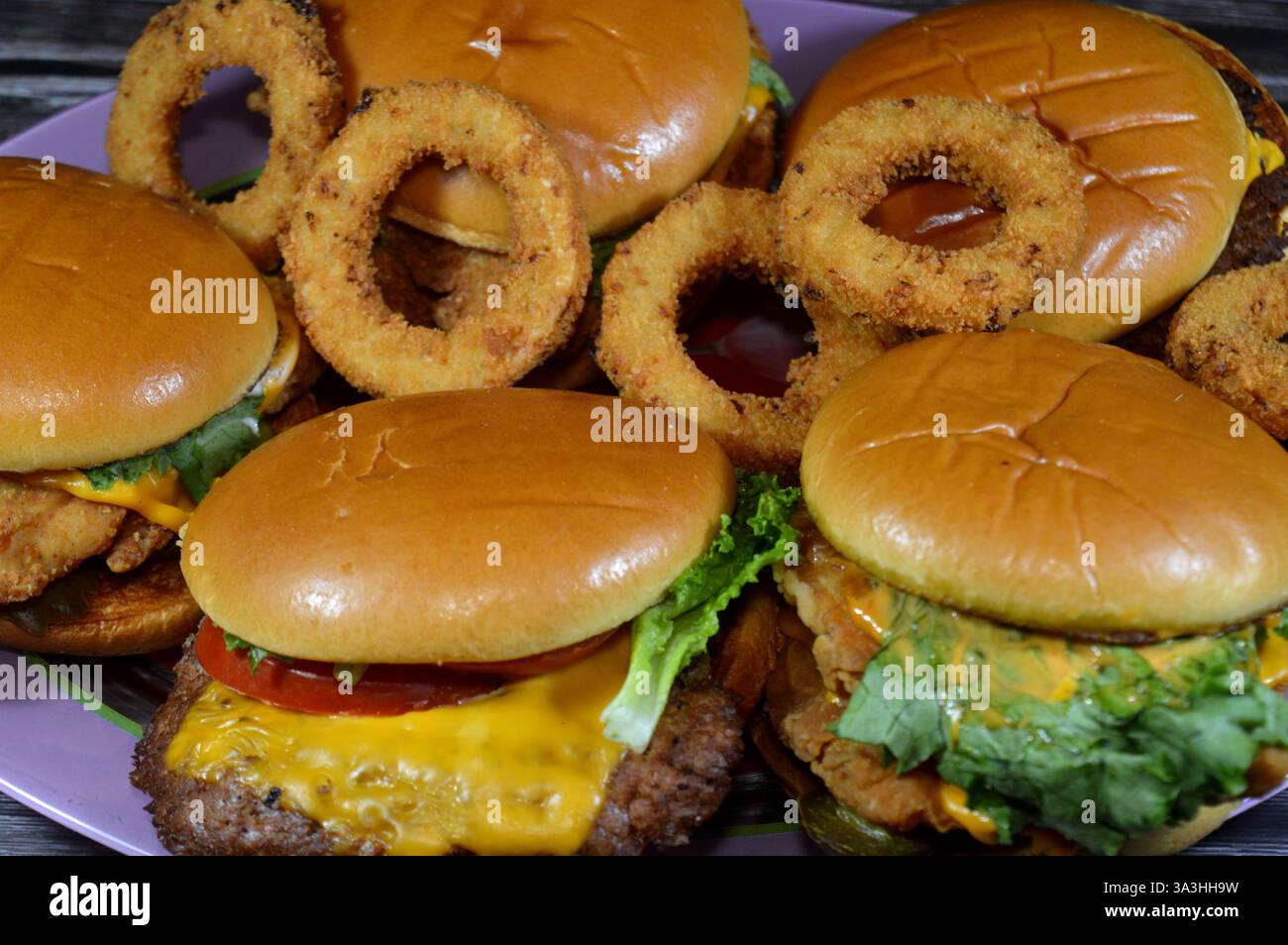 Fried onion rings with assorted sandwiches of cheeseburger, a hamburger ...