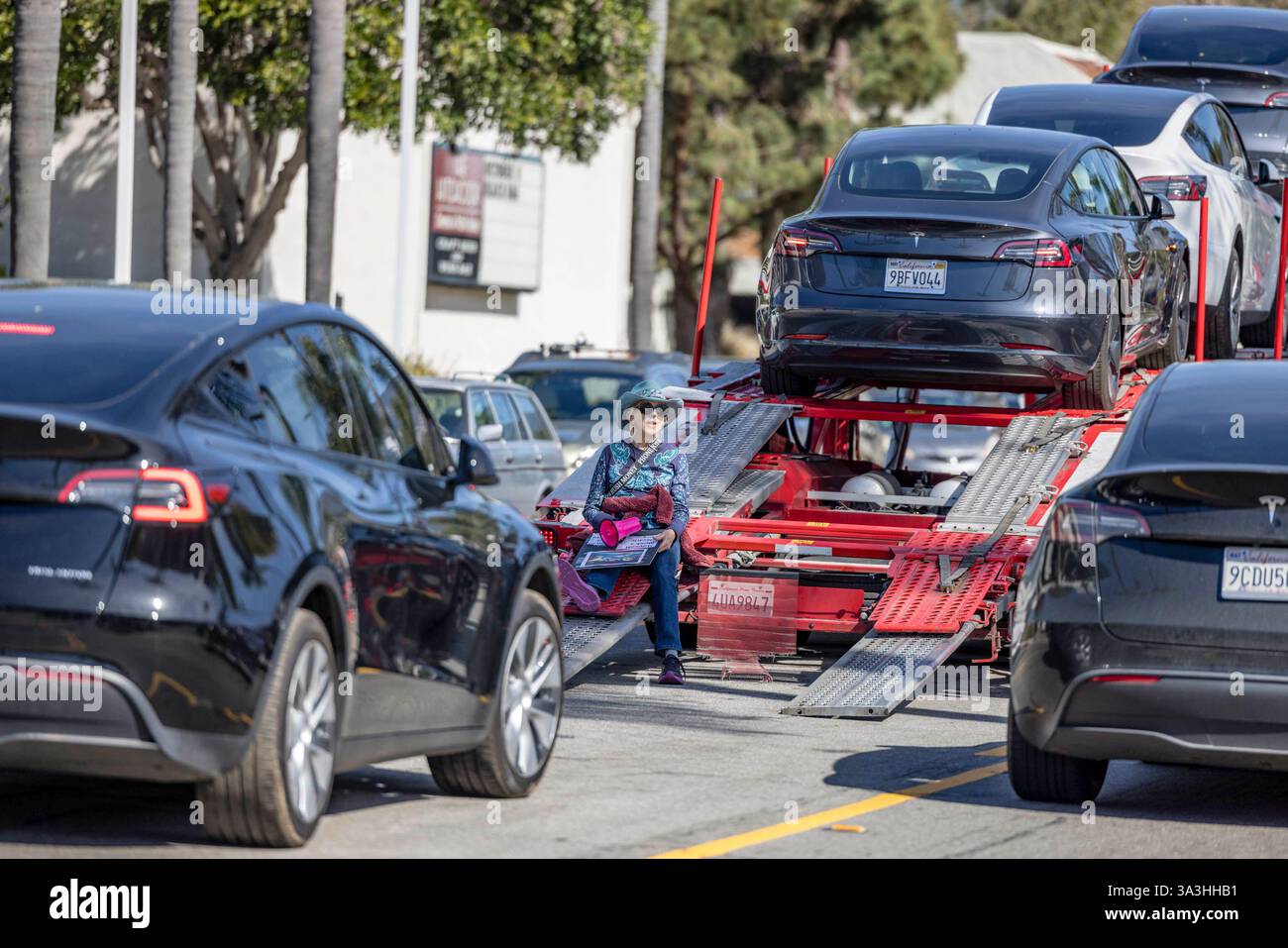 Protesters obstruct the loading of a Tesla vehicle onto a transport ...