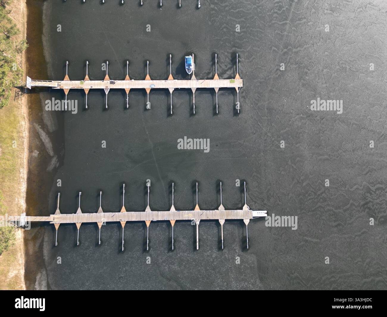 Aerial view of docks over water with a single blue boat Stock Photo - Alamy
