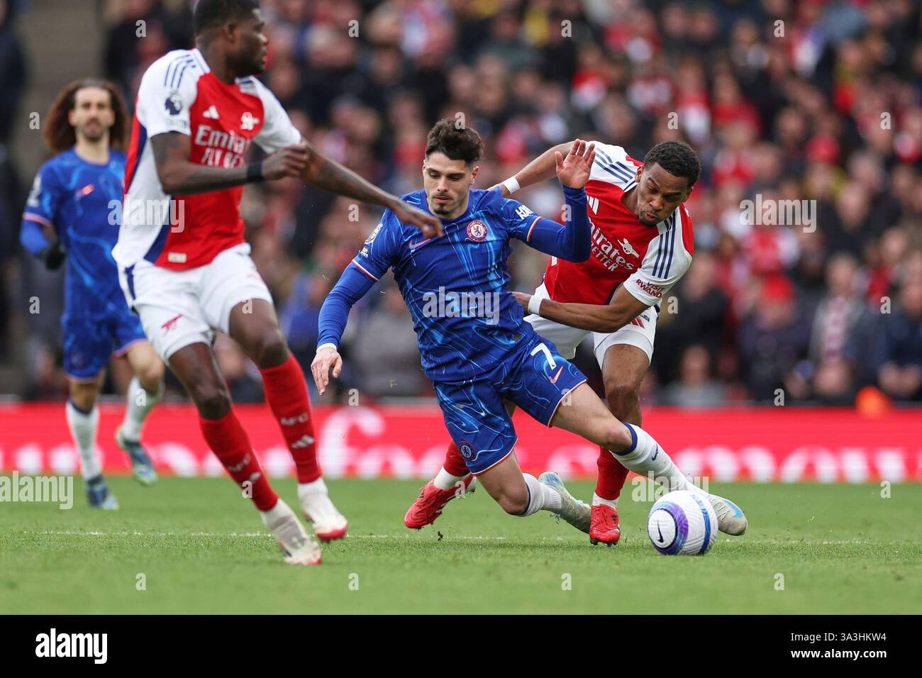 Chelsea's Pedro Neto, centre, challenges for the ball with Arsenal's ...