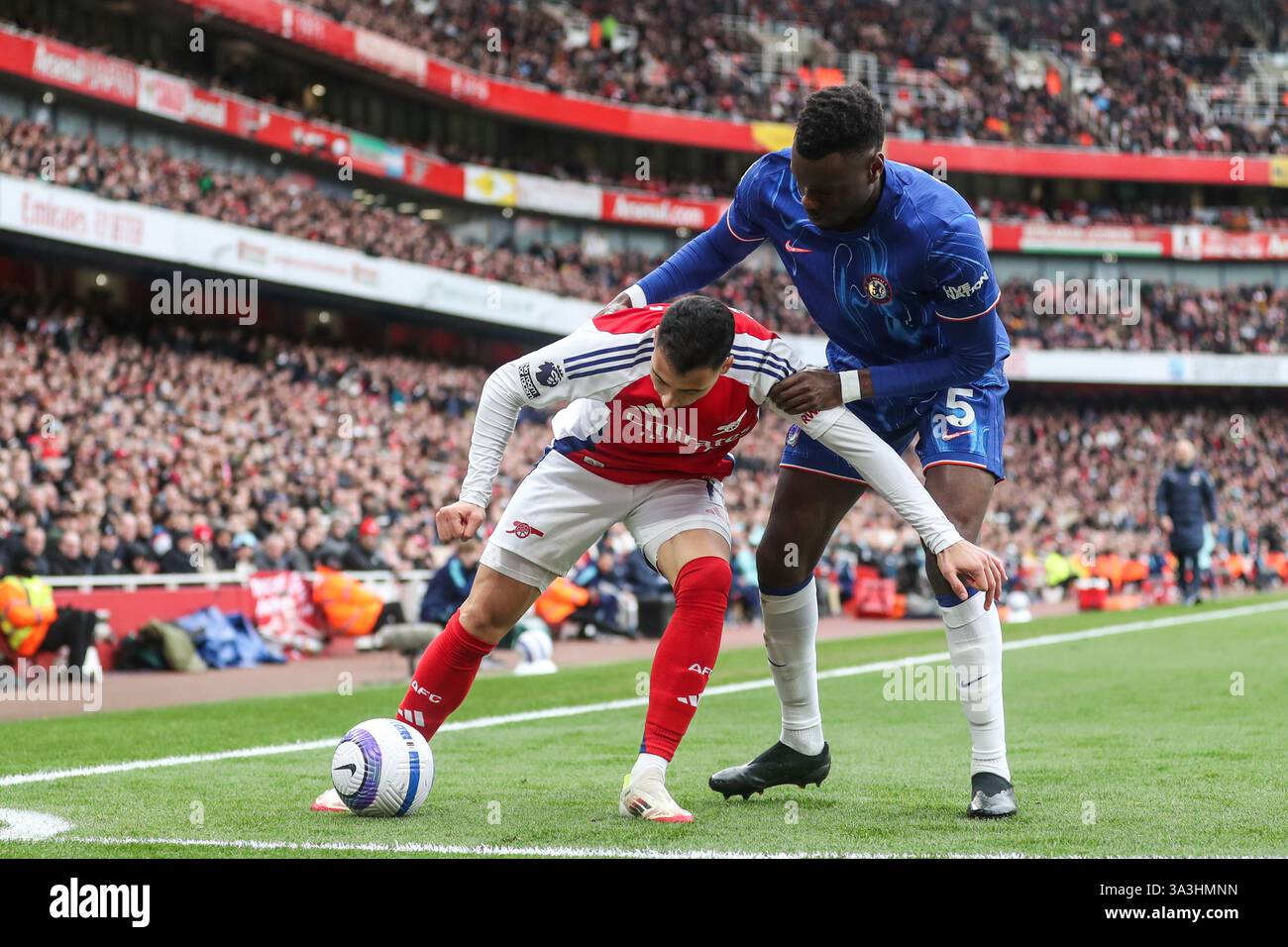 Gabriel Martinelli of Arsenal holds off Benoît Badiashile of Chelsea ...