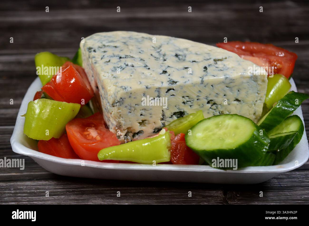 Blue cheese with slices of green chili peppers, tomatoes and cucumbers ...