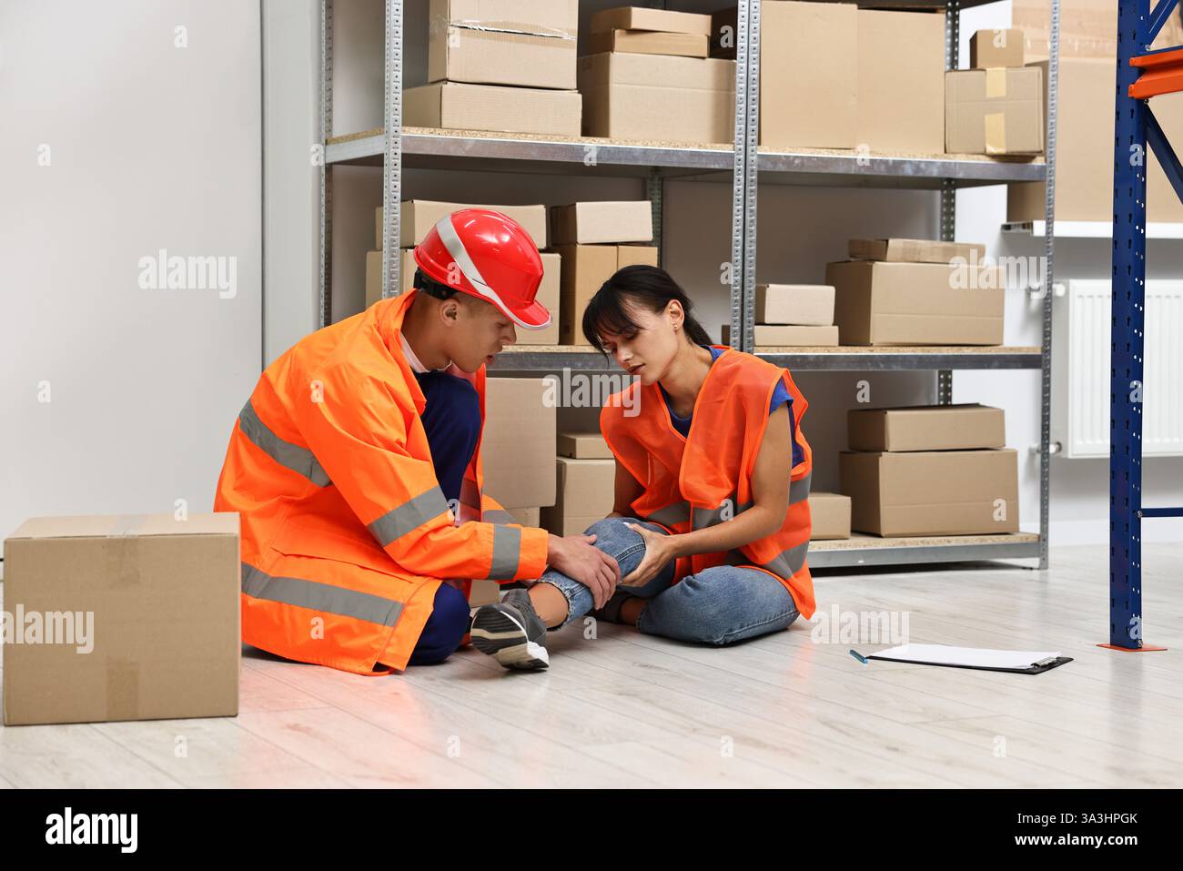 Accident at work. Man helping his injured colleague in warehouse Stock ...