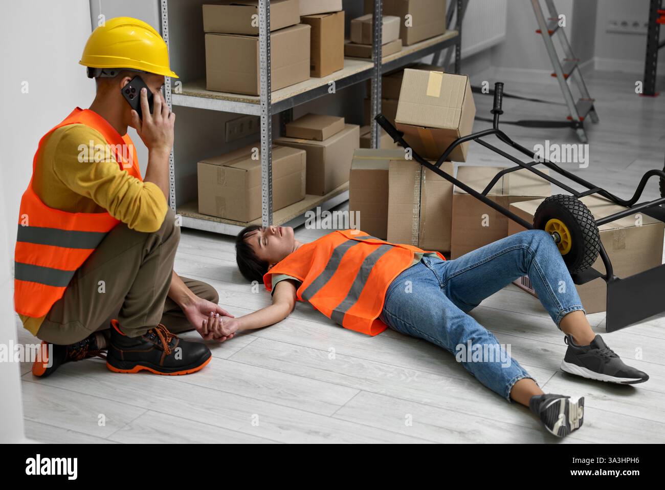 Accident at work. Man calling ambulance for his unconscious colleague ...
