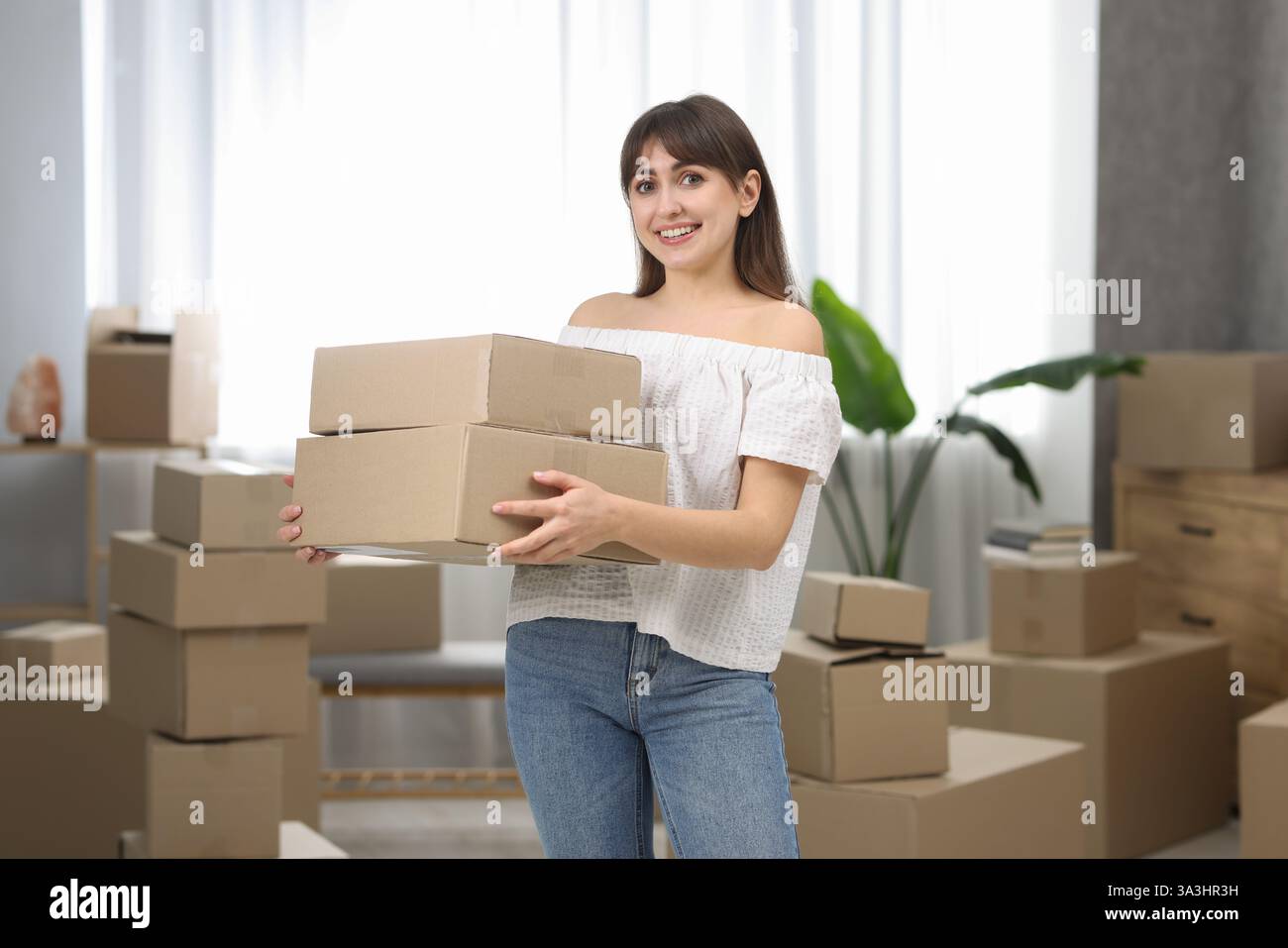 Moving day. Happy woman with cardboard boxes in her new home Stock ...