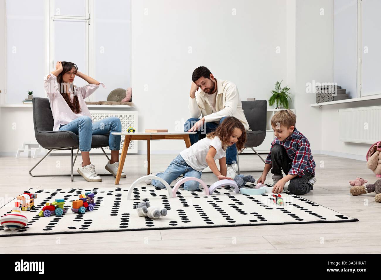 Hyperactive children playing and their overwhelmed parents at home ...