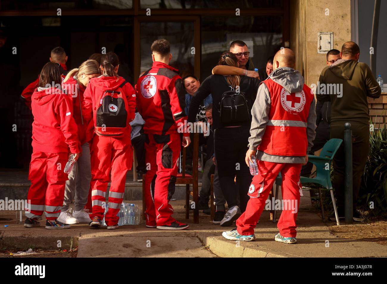 People hug outside a hospital in the town of Kocani, North Macedonia ...