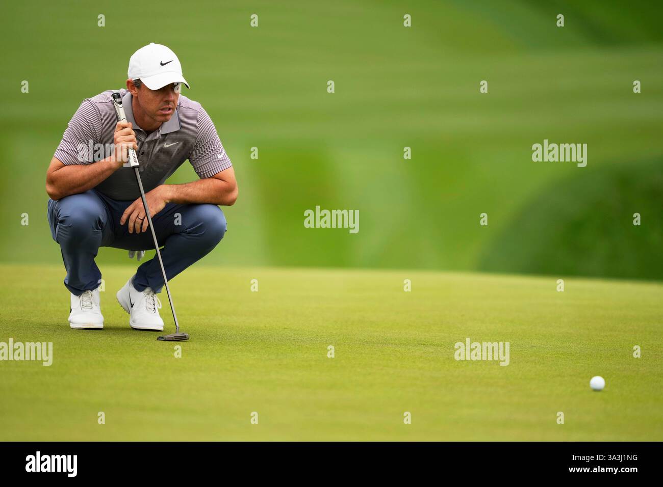 Rory McIlroy, of Northern Ireland, lines up a shot on the second hole ...