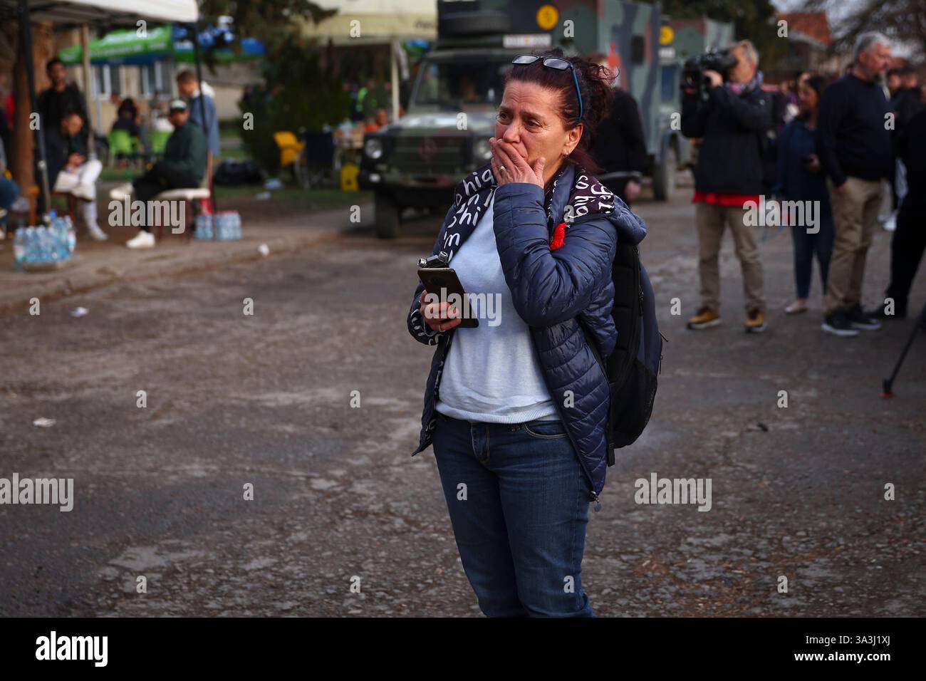 A woman reacts standing outside a hospital in the town of Kocani, North Macedonia, Sunday, March ...