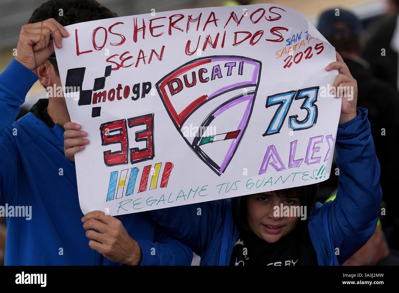 A spectator holds a banner reading in Spanish "Brothers, be united" in ...