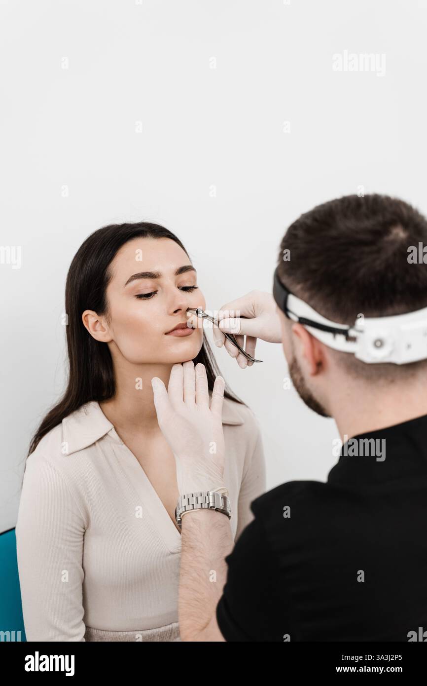 Otolaryngologist examines girl nose before procedure of endoscopy of ...