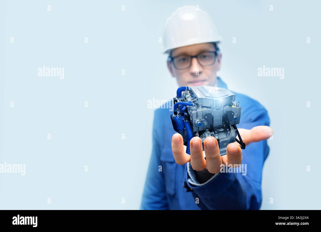 Engineer with digital tablet holds model of hydrogen fuel cell engine ...