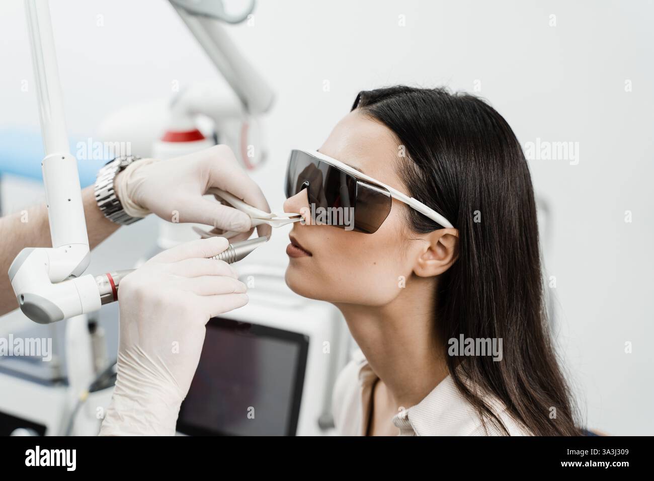 Laser treatment of chronic rhinitis. ENT doctor with laser treats girl ...