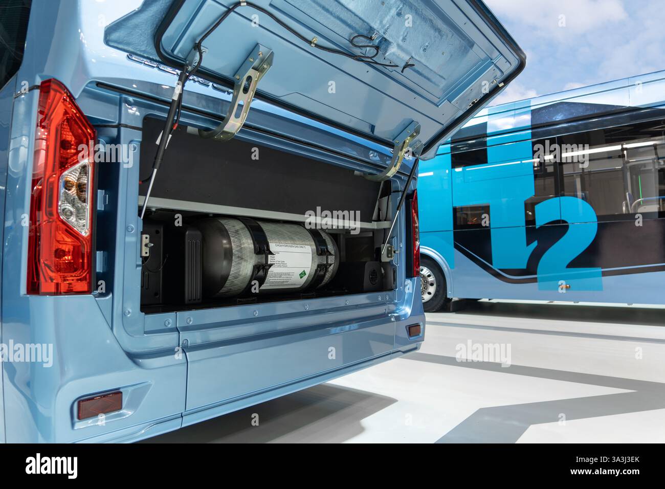 A hydrogen fuel cell buses. One bus with an open hood and a hydrogen ...