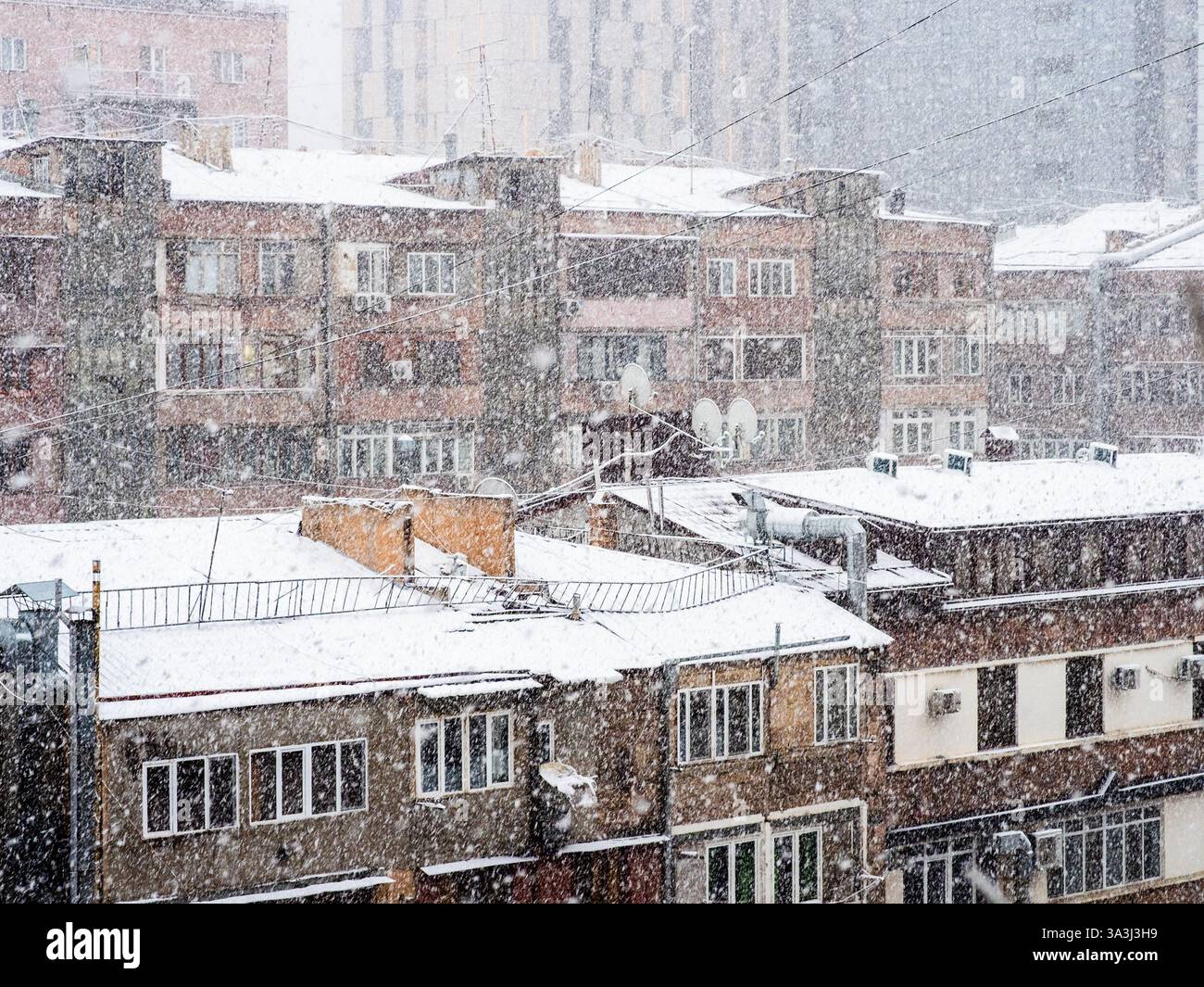 snowfall over apartment buildings on winter day in Yerevan city ...