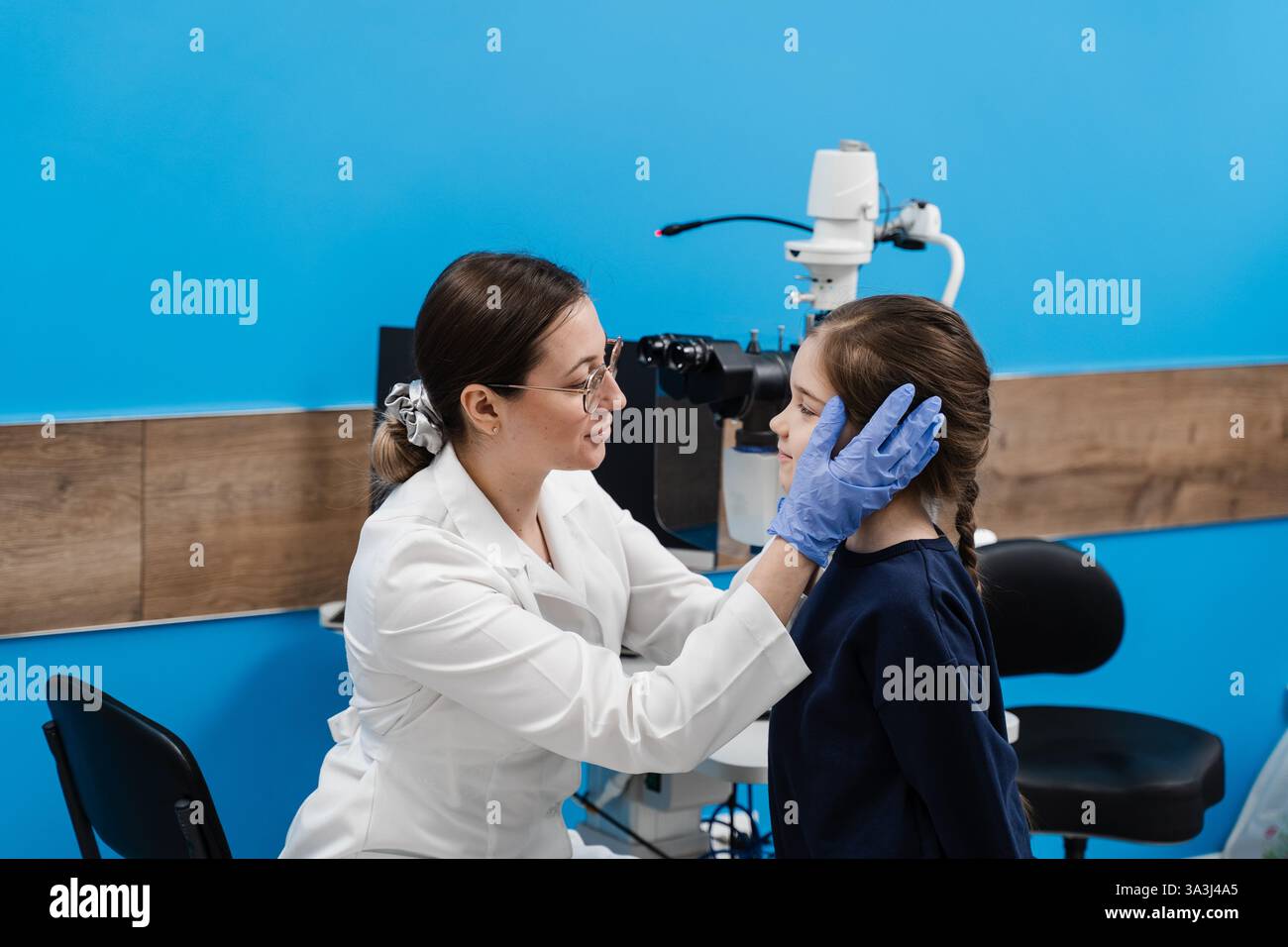 Pediatric ophthalmologist examines eyes and pupil of child ...