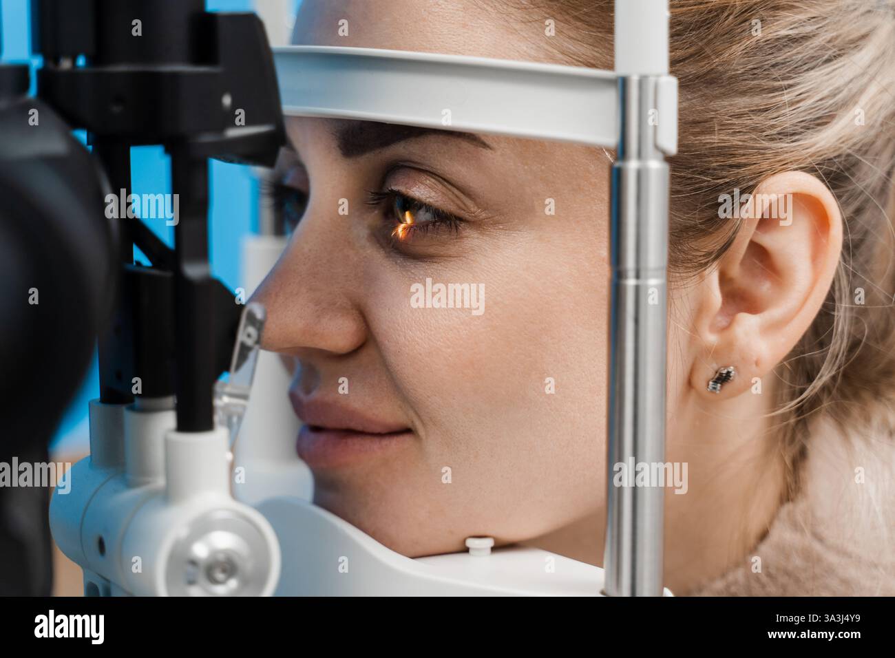 Ophthalmologist illuminates eye of child with light from slit lamp to ...