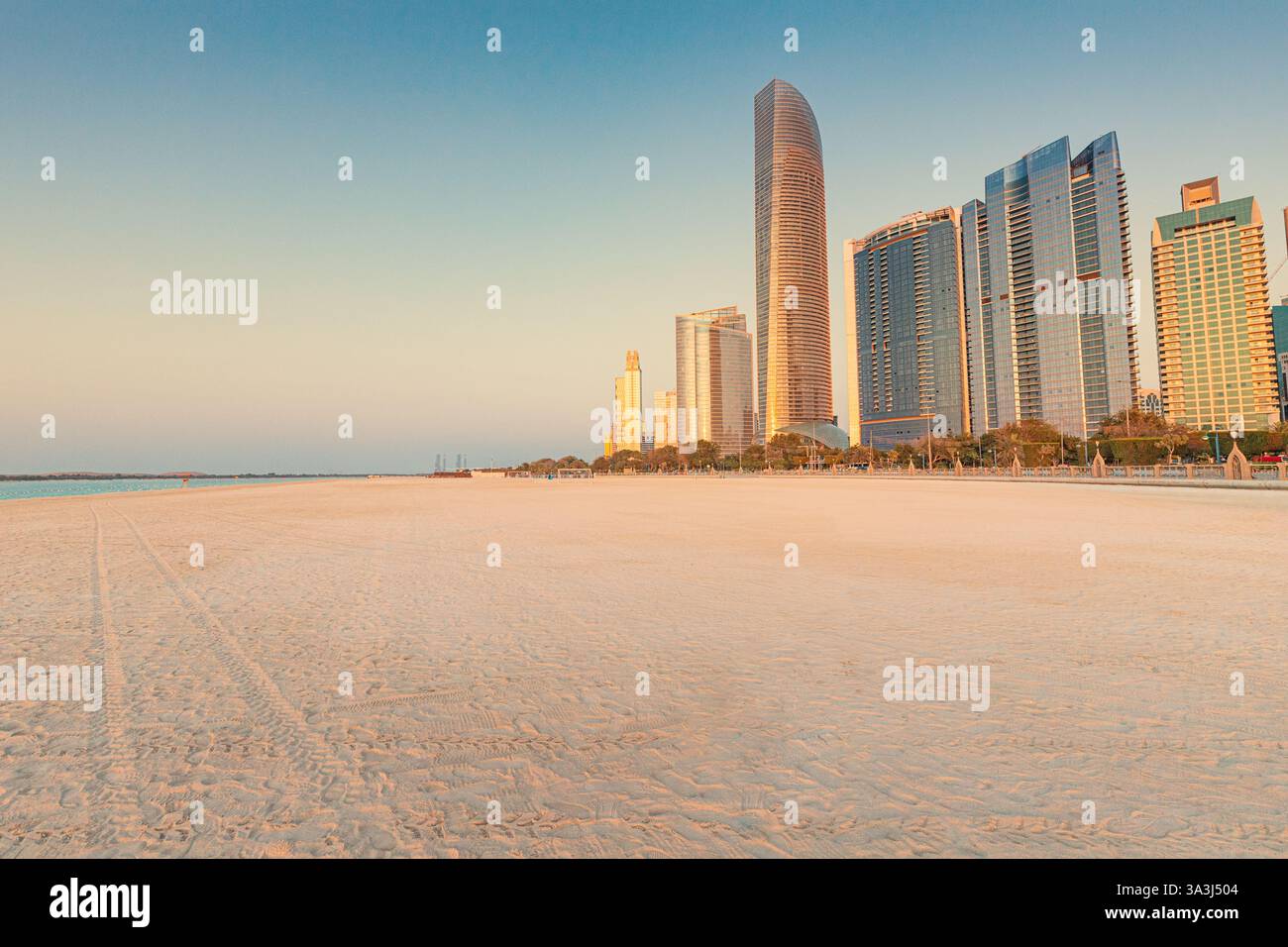 Scenic view of Abu Dhabi Corniche beach during sunrise with modern ...