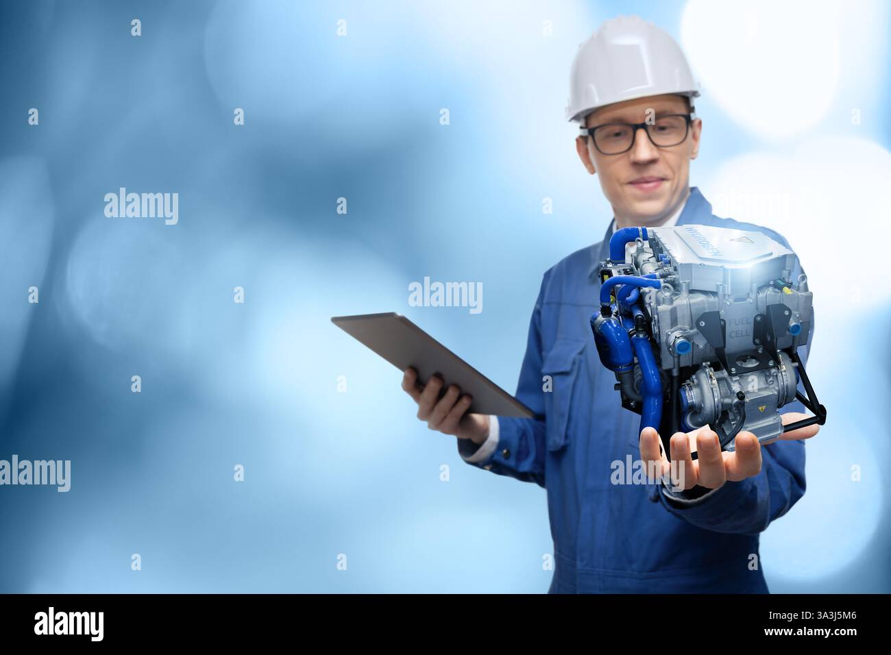 Engineer with digital tablet holds model of hydrogen fuel cell engine ...