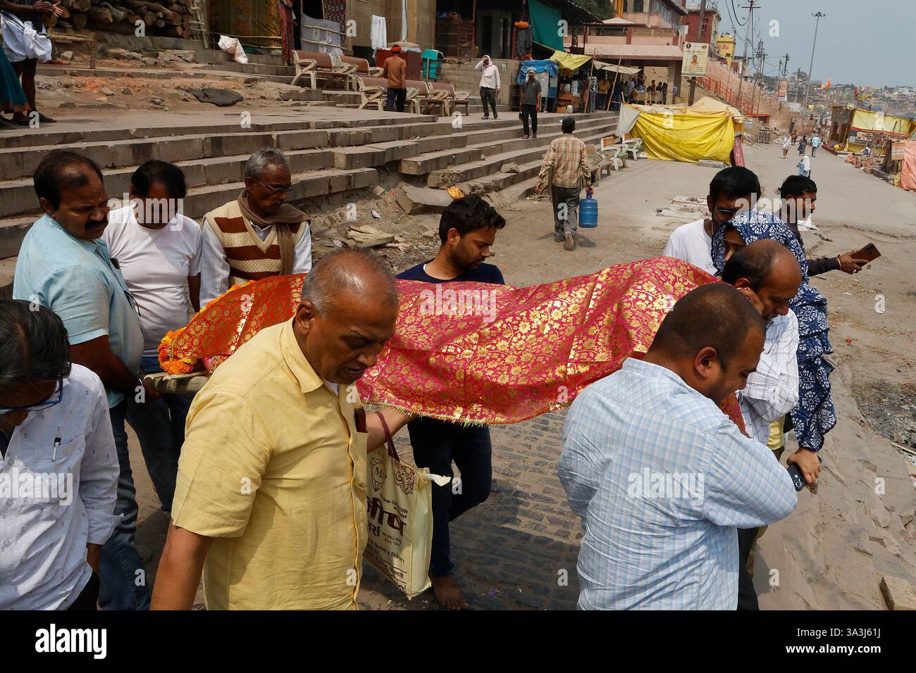 The shrouded body of a deceased person is carried to a funeral pyre on ...