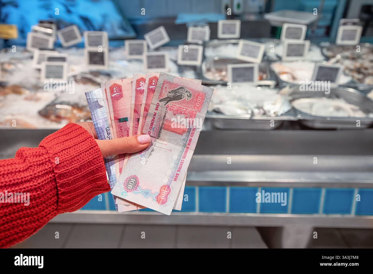 Customer holding some United Arab Emirates Dirham banknotes ready to ...