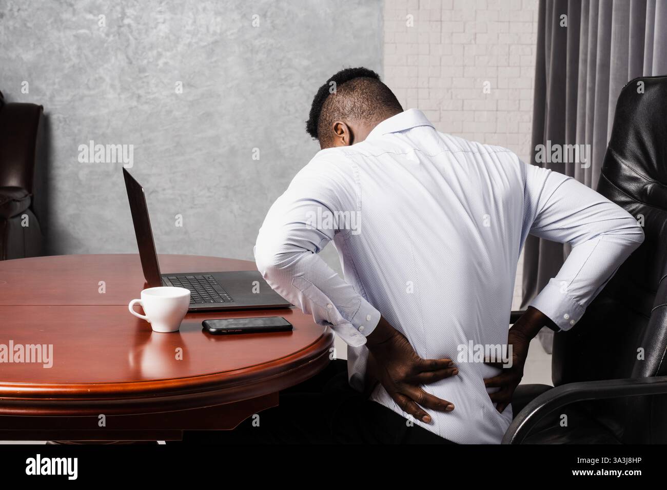 African man feels back pain after working for long hours with laptop ...
