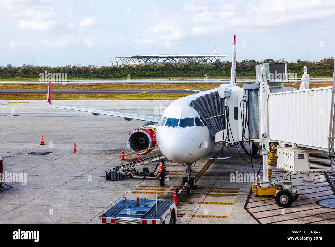 Airplane parked at airport gate with jet bridge connected for passenger ...