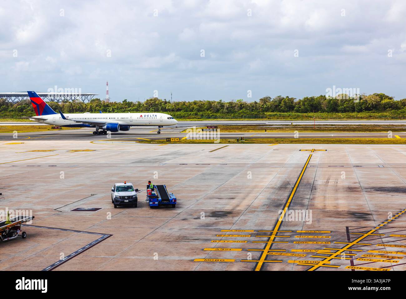 Delta Air Lines aircraft taxiing on runway at airport against blue sky ...