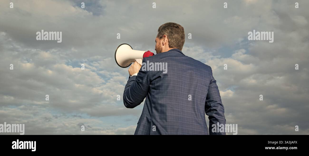 back view of businessman shout in loudspeaker on sky background ...
