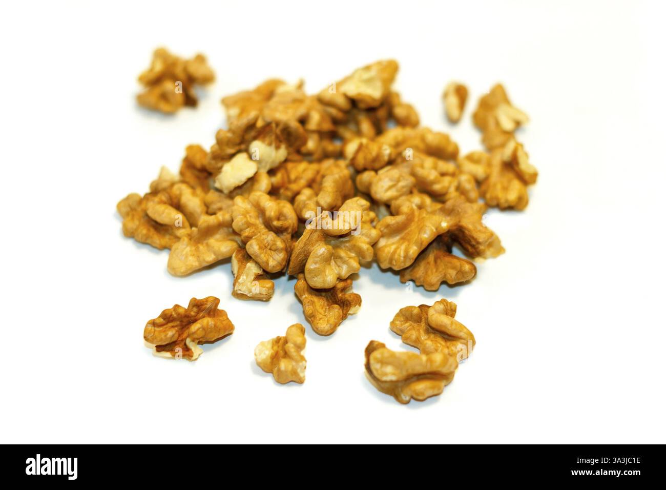 Peeled walnut kernels lie in a group on a white background, ready to ...