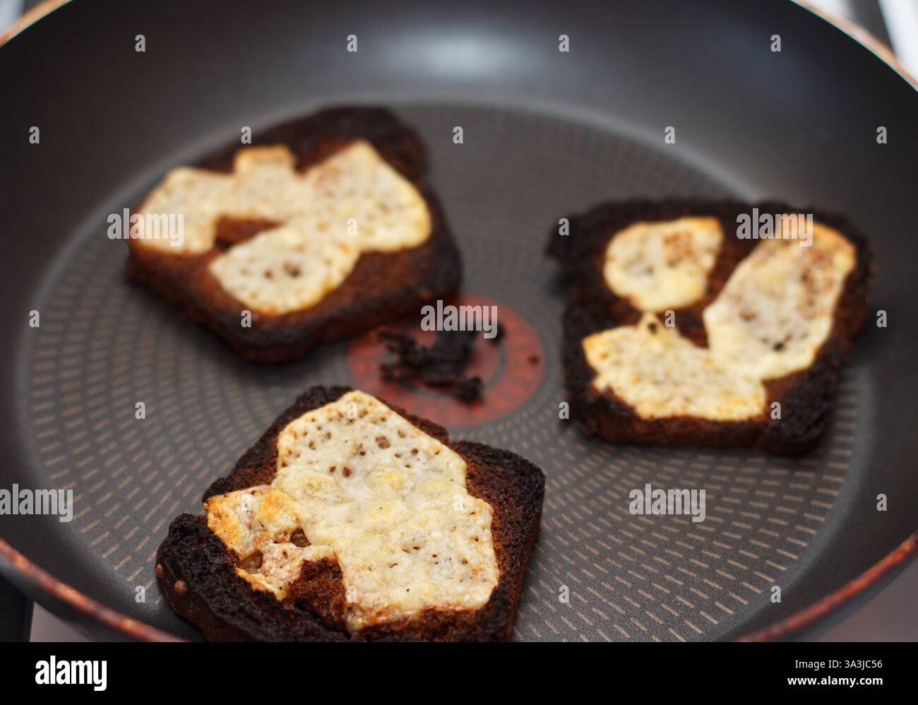 Three cheese sandwiches with cheese burned in the pan to black Stock ...