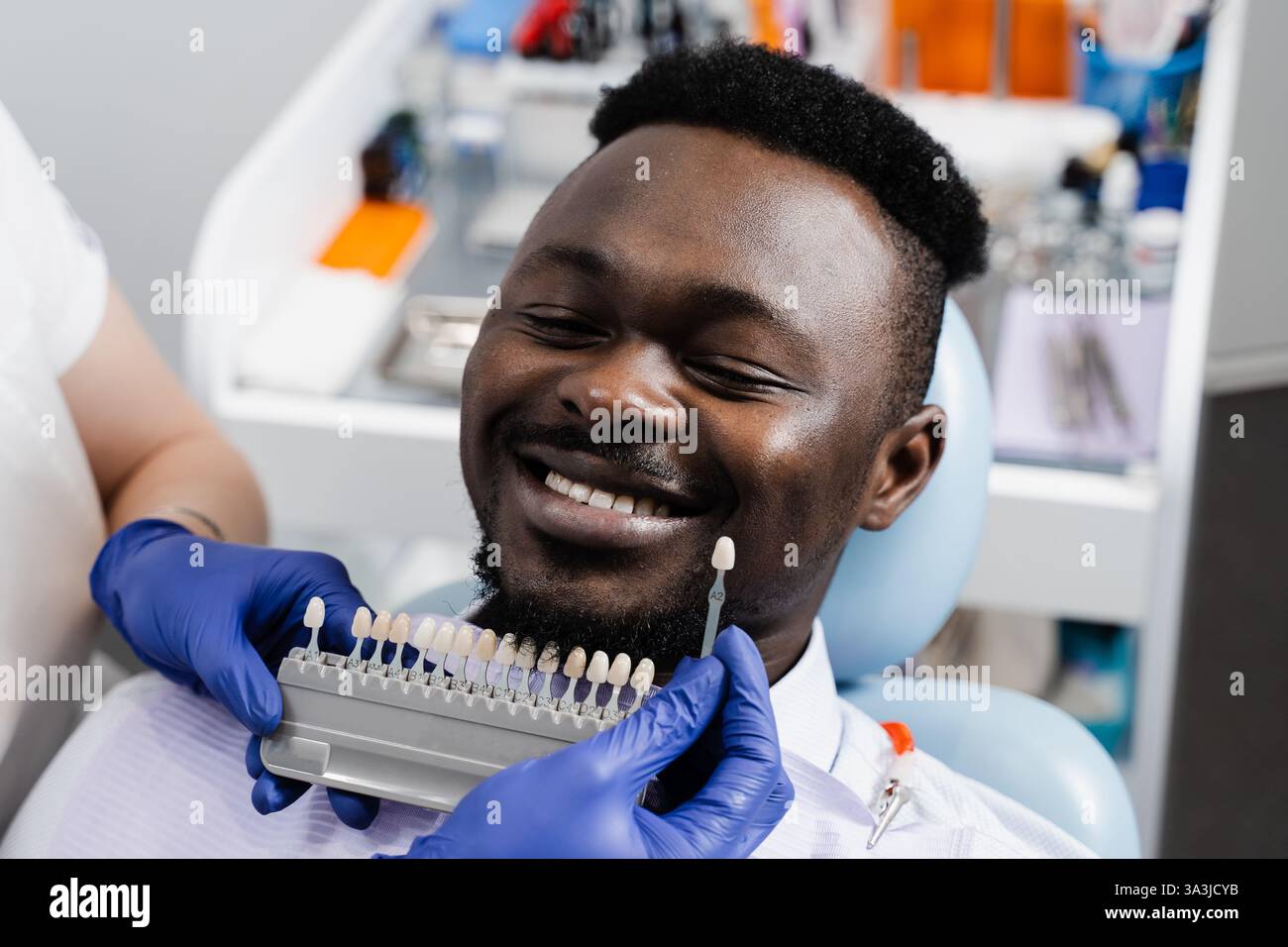 Teeth color shades guide close-up. African man in dentistry. Veneers or ...