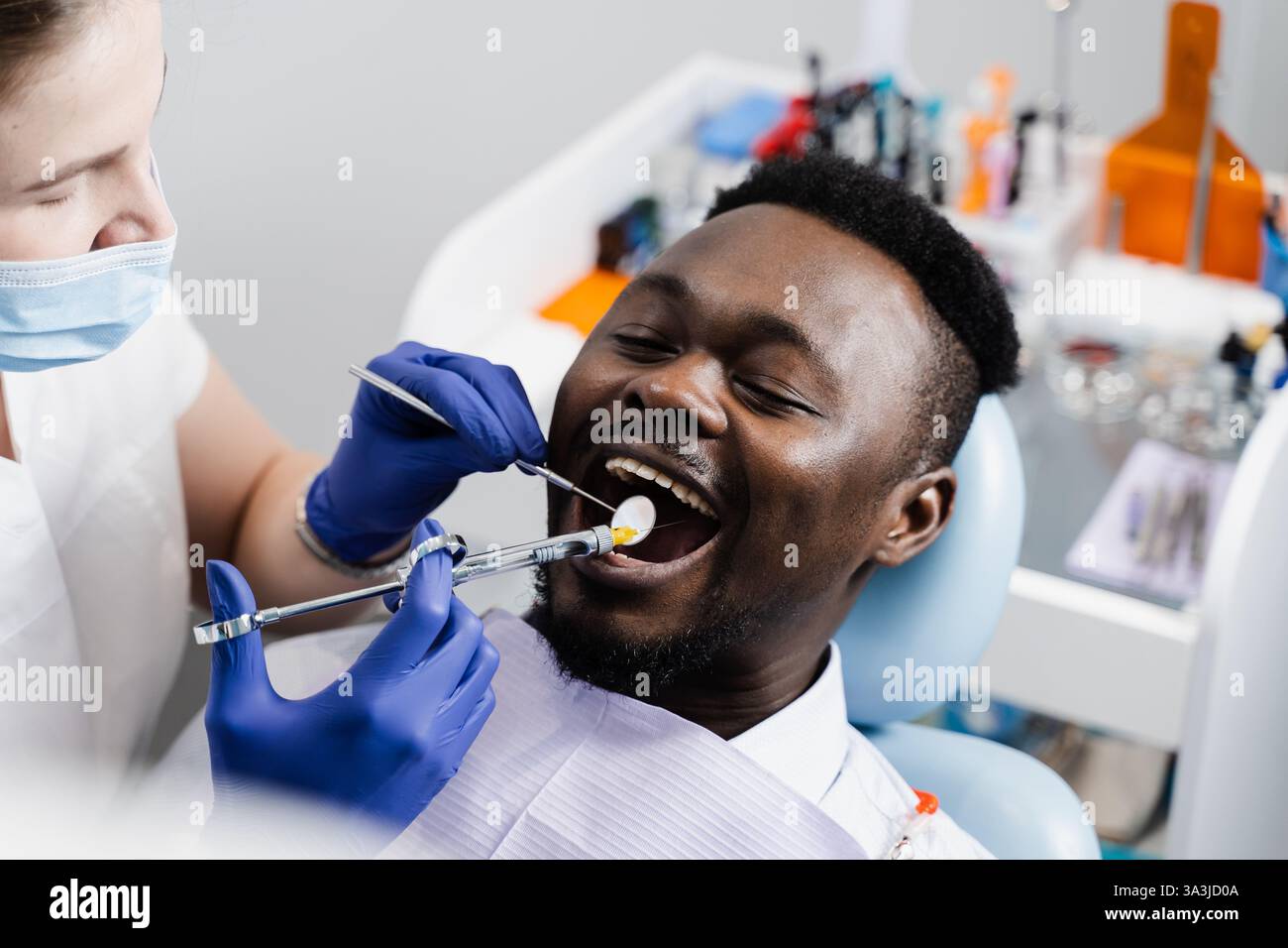 Dentist injects syringe with anesthesia in mouth of african man for ...