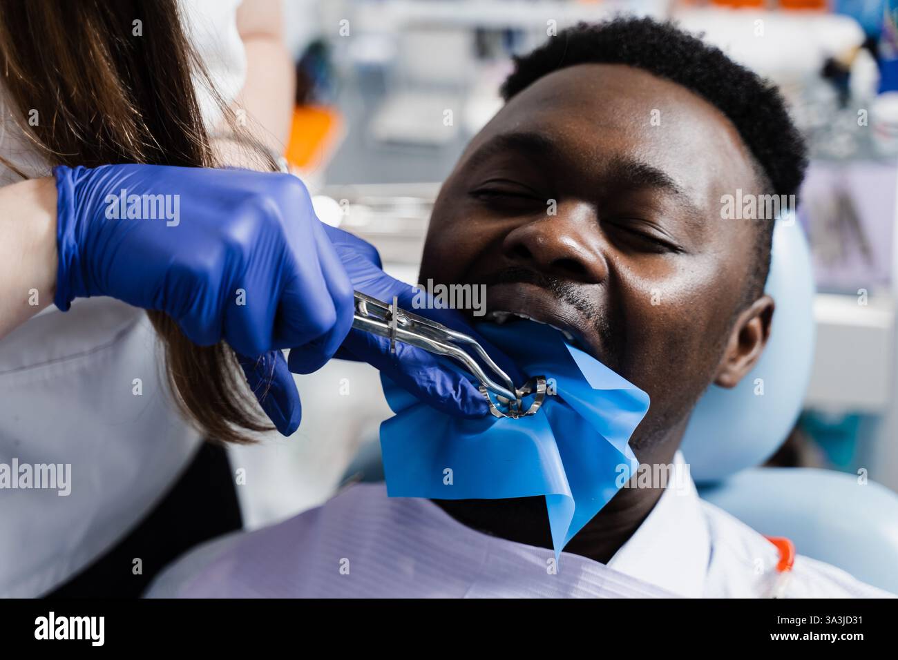Process of installing dental cofferdam in jaw of african man for ...