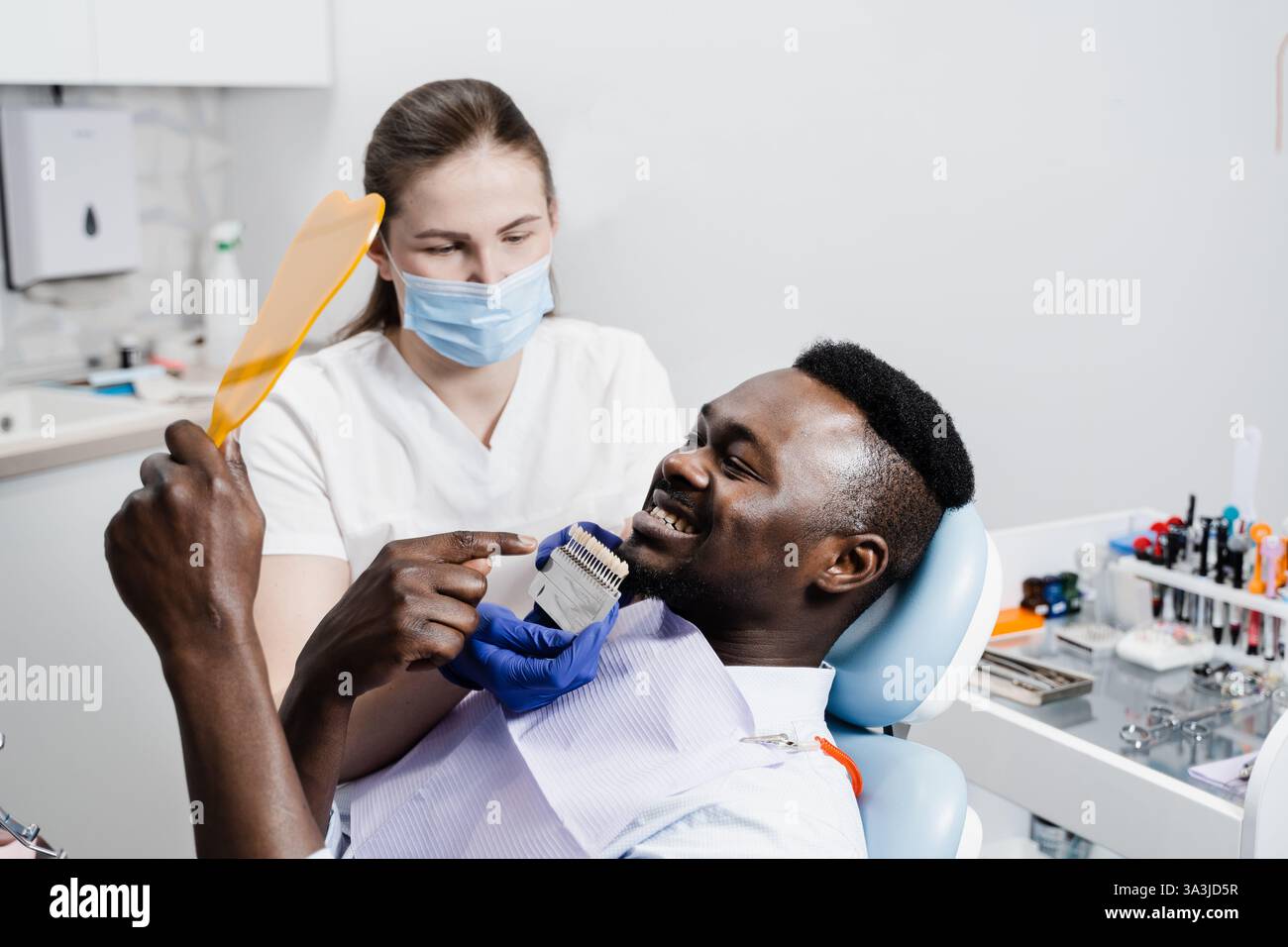 Dentistry. Dentist showing teeth color shades guide for tooth whitening ...