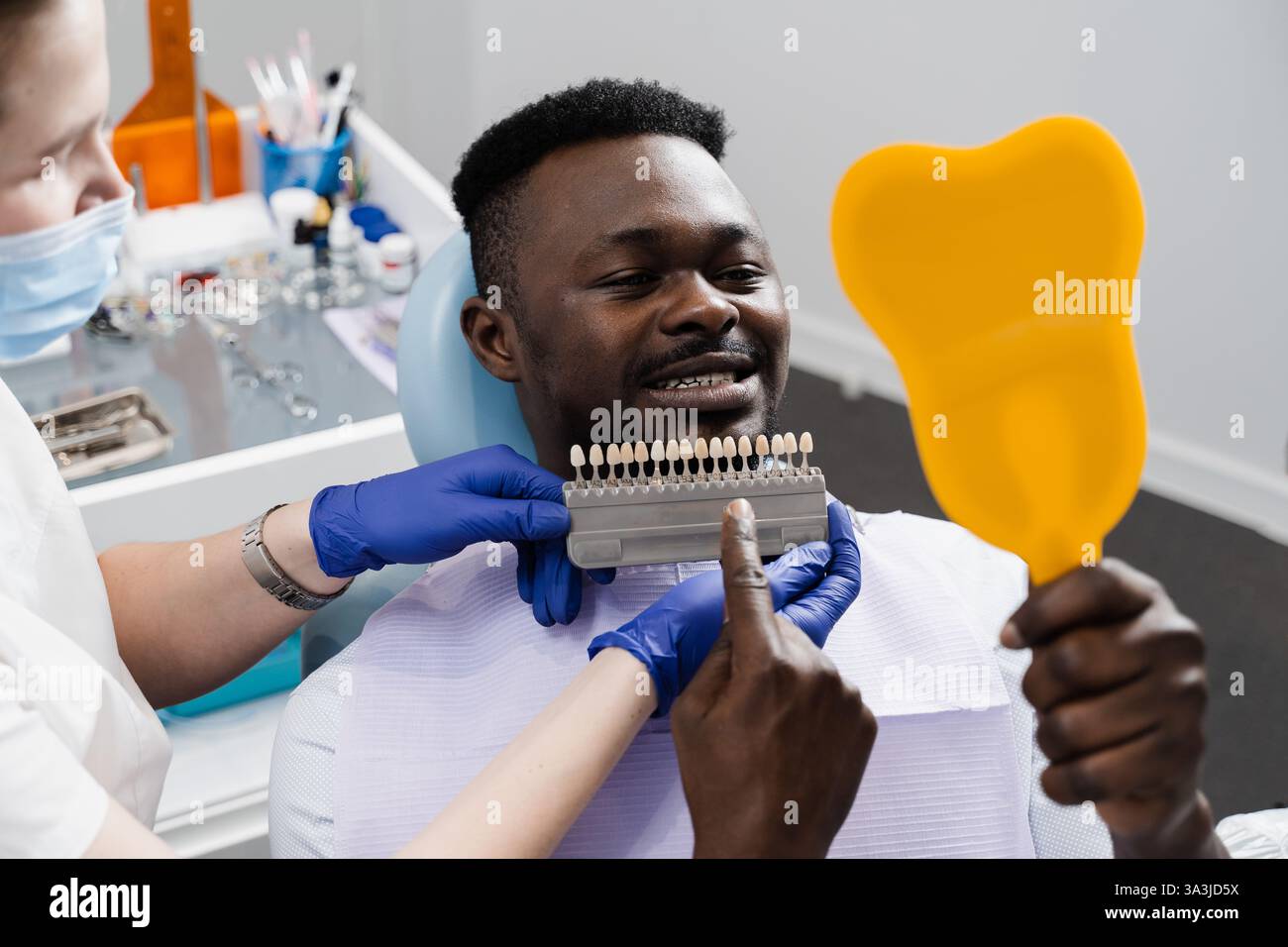 Dentistry. Dentist showing teeth color shades guide for tooth whitening ...