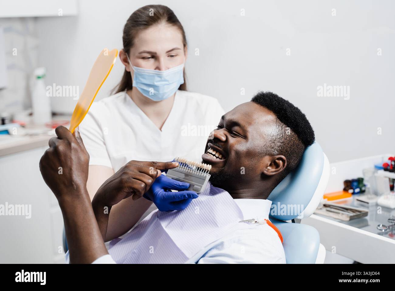 Dentistry. Doctor checking teeth color matching samples in dental ...